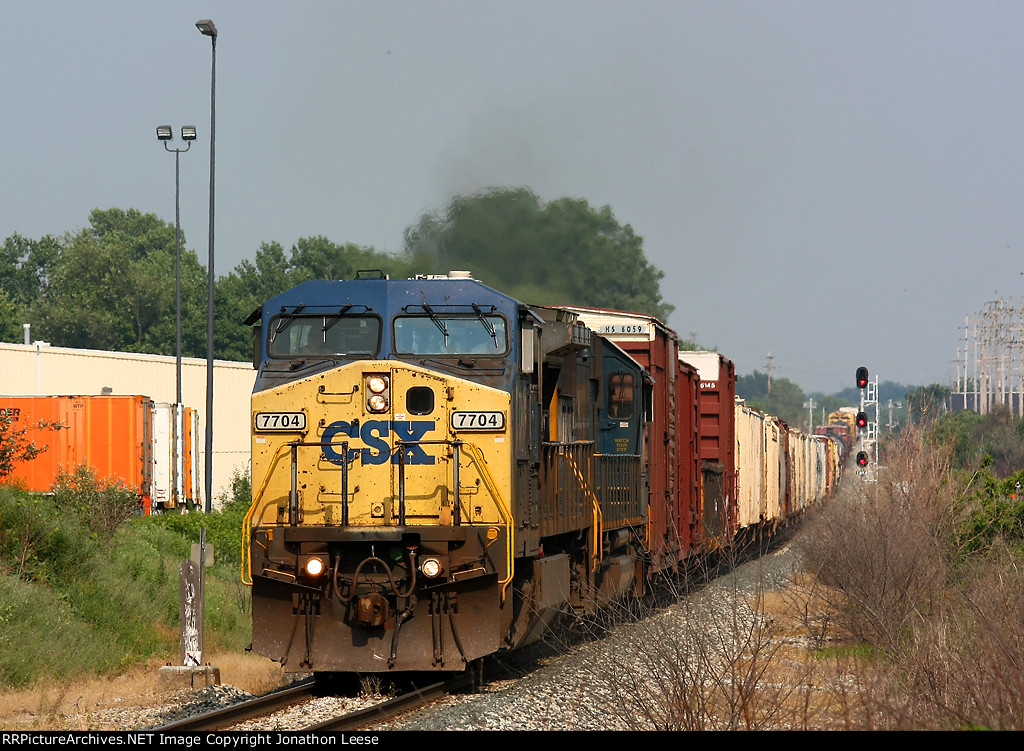 CSX 7704 leads Q335-10 past the signals at CH 146